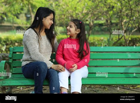 Mother And Daughter Enjoying In Park Surrounded With Greenery And