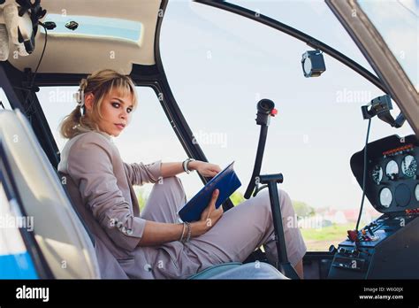 Female Pilot In Cockpit Of Helicopter Before Take Off Young Woman