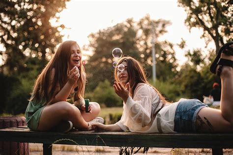Happy Lesbian Couple Playing With Bubbles Relaxing In Park In Summer