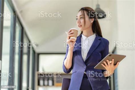 밝고 현대적인 사무실에서 책상에 앉아 태블릿 컴퓨터로 일하는 아시아 사업가 그래프 문서로 재무 보고서 비용 계산 경매에 대한