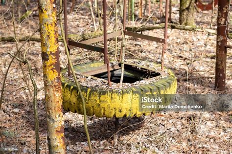 유령 마을 Pripyat 체르노빌 배제 구역 우크라이나에서 나무 들 사이 버려진 놀이터에 금속과 자동차 타이어로 만든 오래 된