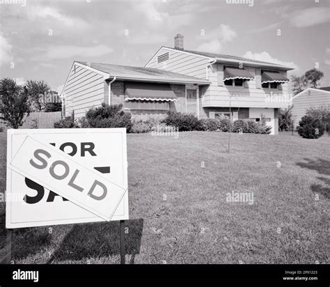 1960s SPLIT LEVEL SUBURBAN HOUSE WITH SOLD SIGN IN FRONT YARD B22878