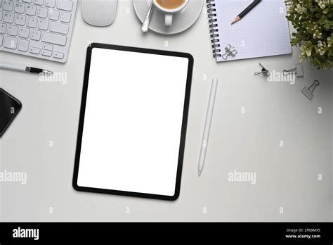 Mock Up Digital Tablet With Blank Screen Plant And Office Supplies On White Office Desk Stock