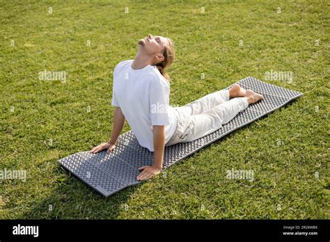 Full Length Of Barefoot Man In White T Shirt And Linen Pants Practicing