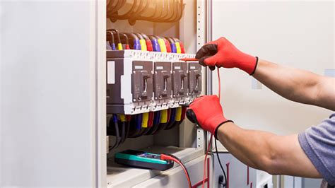 전기 엔지니어는 유지 보수를 위해 정기적으로 전기 제어 캐비닛의 작동을 테스트합니다 건설 산업에 대한 스톡 사진 및 기타 이미지