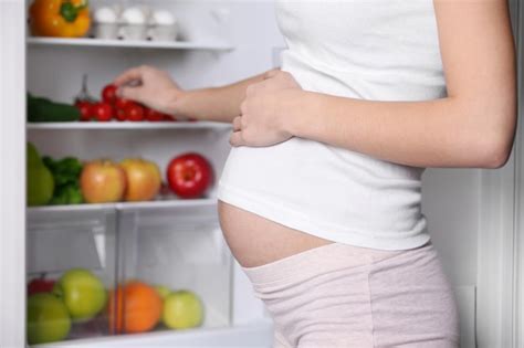 Premium Photo Pregnant Woman Standing Near Refrigerator Full Of