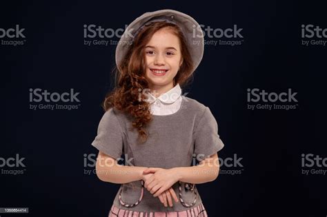 검은 배경에 포즈를 취하는 길고 곱슬 곱슬 한 머리와 사랑스러운 작은 아이의 스튜디오 샷 갈색 머리에 대한 스톡 사진 및 기타