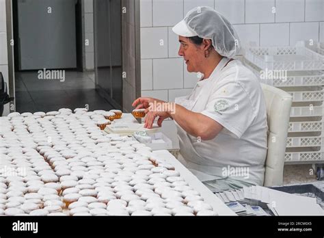 Las mujeres panaderas empaquetan las queijadas recién azucaradas una
