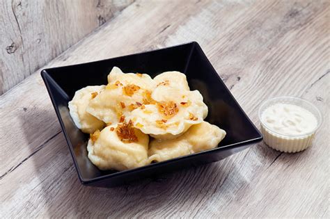 양배추와 감자와 만두에 가까운 보기 어두운 접시에 사워 크림 나무 테이블에 서 우크라이나어 음식입니다 디자인을 위한 공간을 복사합니다 바레니키 주 0명에 대한 스톡 사진 및