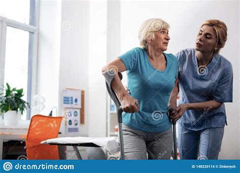 Nette Angenehme Krankenschwester Die Ihren Patienten Hilft Zu Gehen
