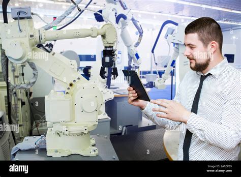 Engineer With Teach Pendant Device Programming Robot With Robotic Arm
