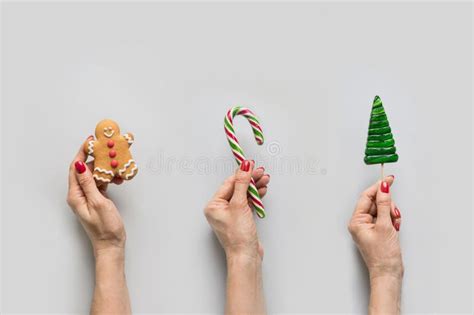 Christmas Traditional Food In Hand Holding Gingerbread Lollipop Candy