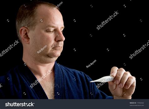 A Man Checking His Temperature With A Thermometer Stock Photo Shutterstock