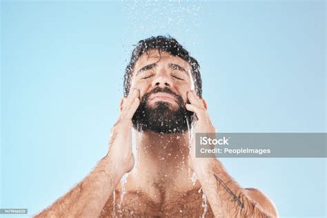 파란색 배경 스튜디오에서 스킨케어 위생 바디 케어 웰빙 및 그루밍 건강을 위한 남성 샤워 및 얼굴 청소 물 튀김 얼굴 스파