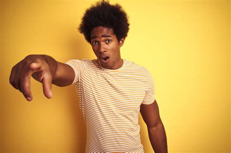 고립 된 노란색 배경 위에 서있는 줄무늬 티셔츠를 입은 미국 남자가 불쾌하고 카메라에 좌절하고 화가 나서 분노합니다 T 셔츠에 대한 스톡 사진 및 기타 이미지 Istock