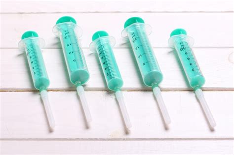 Vista superior de jeringas de diferentes tamaños sobre fondo de madera equipo médico para