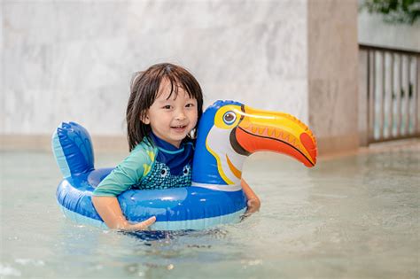 재미 풍선 혼빌 플로트 링에 수영장에서 어린 소년의 초상화 수영하는 방법을 배우고 여름과 휴가 행복한 아시아 가족 개념 놀이에