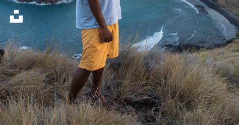 Foto Un Hombre Parado En La Cima De Una Exuberante Ladera Verde