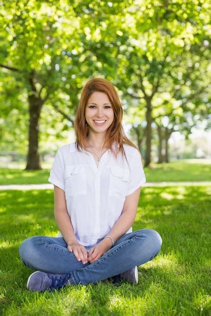 Linda Pelirroja Sonriendo A La Cámara En El Parque Foto Premium