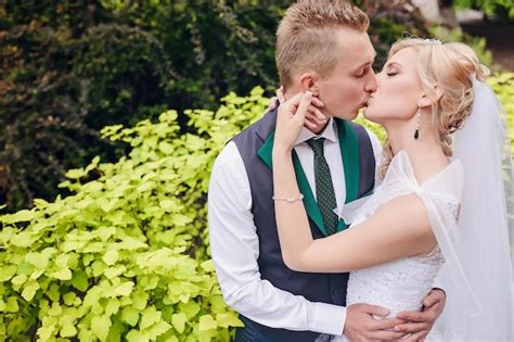 Premium Photo Bride And Groom Kissing In The Park