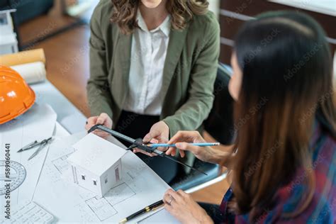 Concept Of Engineering Consulting Two Female Engineers Discussing About Model Of Building