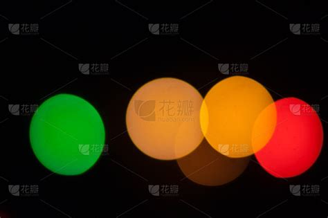 彩色抽象模糊散焦散焦灯光在黑色背景。绿色、橙色和红色的斑点