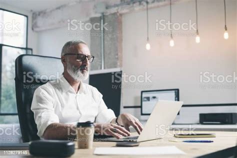 나무 테이블에 현대 Coworking 사무실에서 작업 하는 동안 모바일 노트북 컴퓨터를 사용 하 여 매력적이 고 긍정적인 성인
