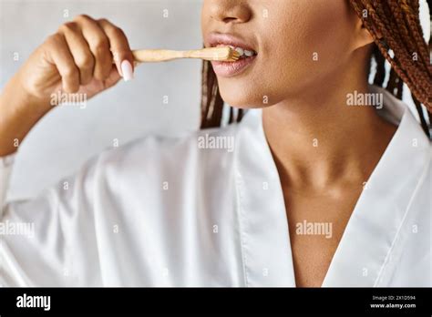 Afro Braided African American Woman In Bathrobe Brushes Teeth With A