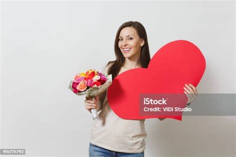젊은 여 자가 큰 레드 심장 흰색 바탕에 아름 다운 장미 꽃의 꽃다발을 들고 꽤 광고에 대 한 공간을 복사 합니다 텍스트에 대 한 장소입니다 성 발렌타인의 날 또는 국제