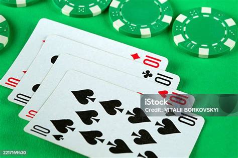 그린 칩과 4 종류 또는 쿼드의 조합이있는 카드 놀이는 클럽의 포커 테이블에 무작위로 배치됩니다 성공적인 승리의 개념 겜블링