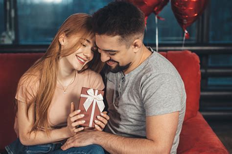 사랑스러운 부부는 선물과 공기 풍선을 들고 소파에 포옹하고 미소 20 24세에 대한 스톡 사진 및 기타 이미지 20 24세 2명 가정 생활 Istock