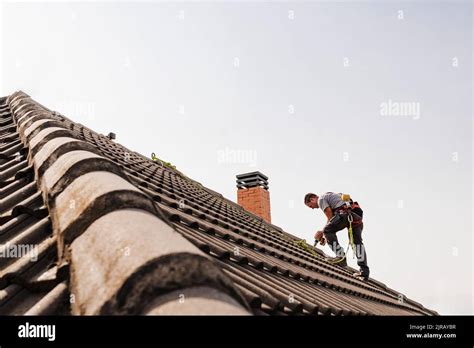 Technician Using Power Tool On Rooftop Stock Photo Alamy