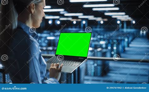 Female It Specialist Using Chroma Key Laptop In Data Center Big Server Farm Cloud Computing
