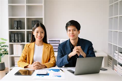 두 명의 아시아 비즈니스 여성과 남성이 사무실에서 태블릿 노트북 컴퓨터로 투자 프로젝트 작업 및 계획 전략에 대해 논의합니다