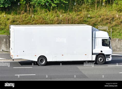 Side View Of A Clean Unmarked All White Hgv Lorry Truck Van Transport With Cab And Driver Without