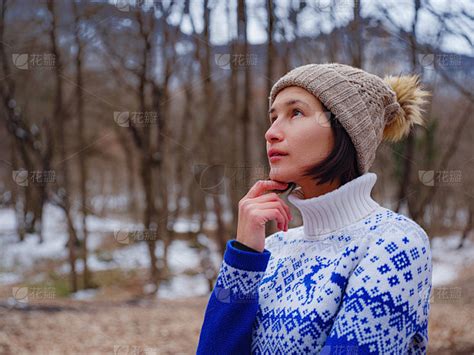 美丽的女人站在冬天的森林里