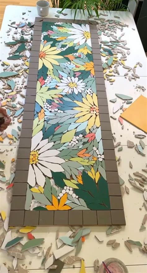 Its A Mosaic With Flowers And A Frame And The Mosaic Is Made Of
