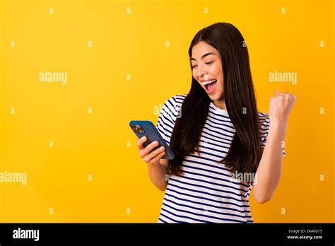 Portrait Of Overjoyed Delighted Girl Raise Fist Celebrate Triumph