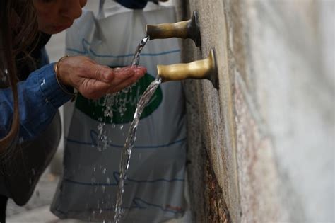 Sección Media De Una Mujer Bebiendo Agua En Una Fuente Foto Premium