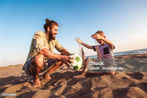 행복 한 아버지와 아들 여름 방학에 좋은 가족 시간을 보내고 해변에서 축구 또는 축구를 재생 합니다 20 29세에 대한 스톡