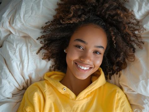 Premium Photo A Curly Haired Girl Lying In Bed Looking At The Camera