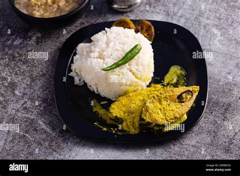 Top View Of Hilsa Fish Curry With Mustard Paste And Green Chilli Served