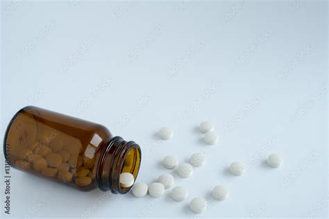 白い錠剤と茶色のガラス瓶 Photos Adobe Stock
