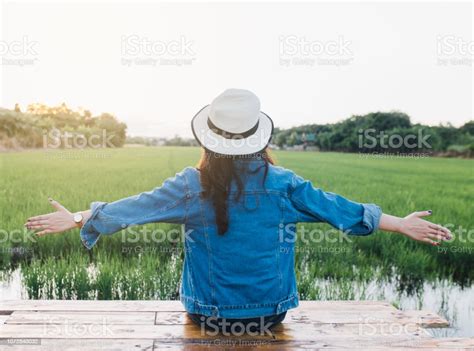 모자에 있는 젊은 여자의 보기를 다시 석양과 아름 다운 자연에서 즐기는 소녀 여행 여름 휴가 휴가 휴식 개념 관광객에 대한 스톡