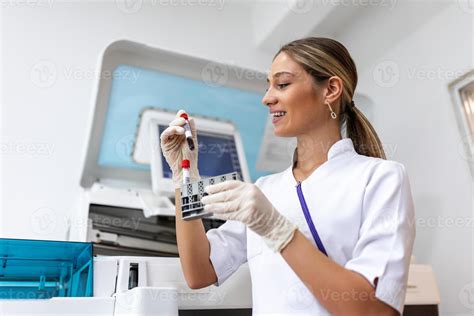 Lab Tech Loading Samples Into A Chemistry Analyzer Female Lab Tech