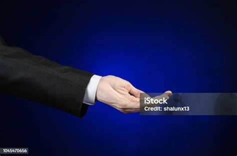 사업가 주제 검은 양복과 흰 셔츠 스튜디오에서 고립 된 어두운 파란색 바탕에 손 제스처를 보여주는 남자 가리키기에 대한 스톡