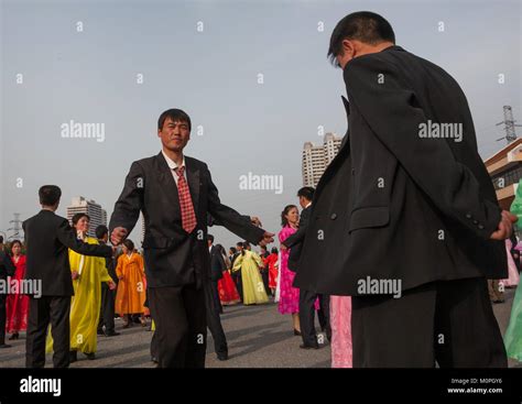 North Korean Young Adults During A Mass Dance Performance In Front Of Buildings On Military