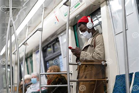 Black Hipster Man In Subway Train Wear Face Mask Using Cellphone