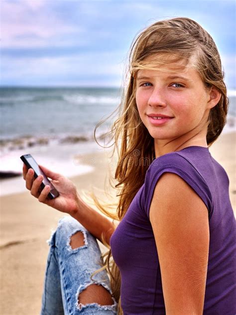 Mädchen Mit Dem Handy Der Auf Sand Nahe Meer Sitzt Stockfoto Bild von internet zelle