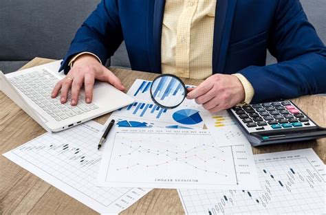 Premium Photo Businessman Analyzing Business Graphs With Magnifying Glass